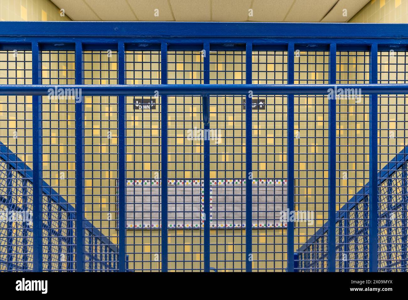 Close-up photo of a blue metal railing at the top of a school staircase ...
