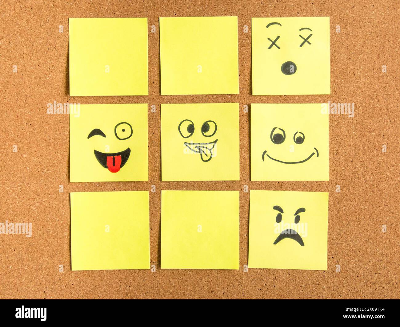 cork board with colorful post its representing various emoticons with ...