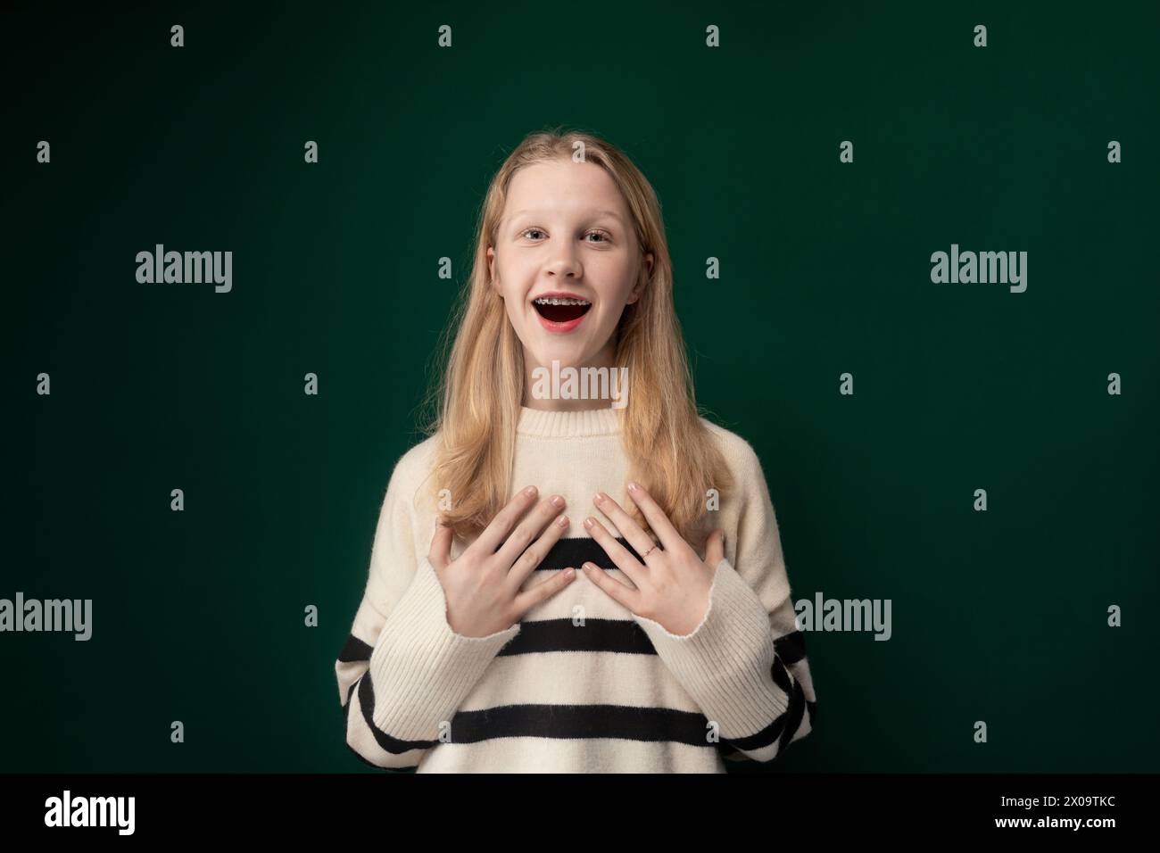 Young Girl Making Funny Face Against Green Background Stock Photo - Alamy
