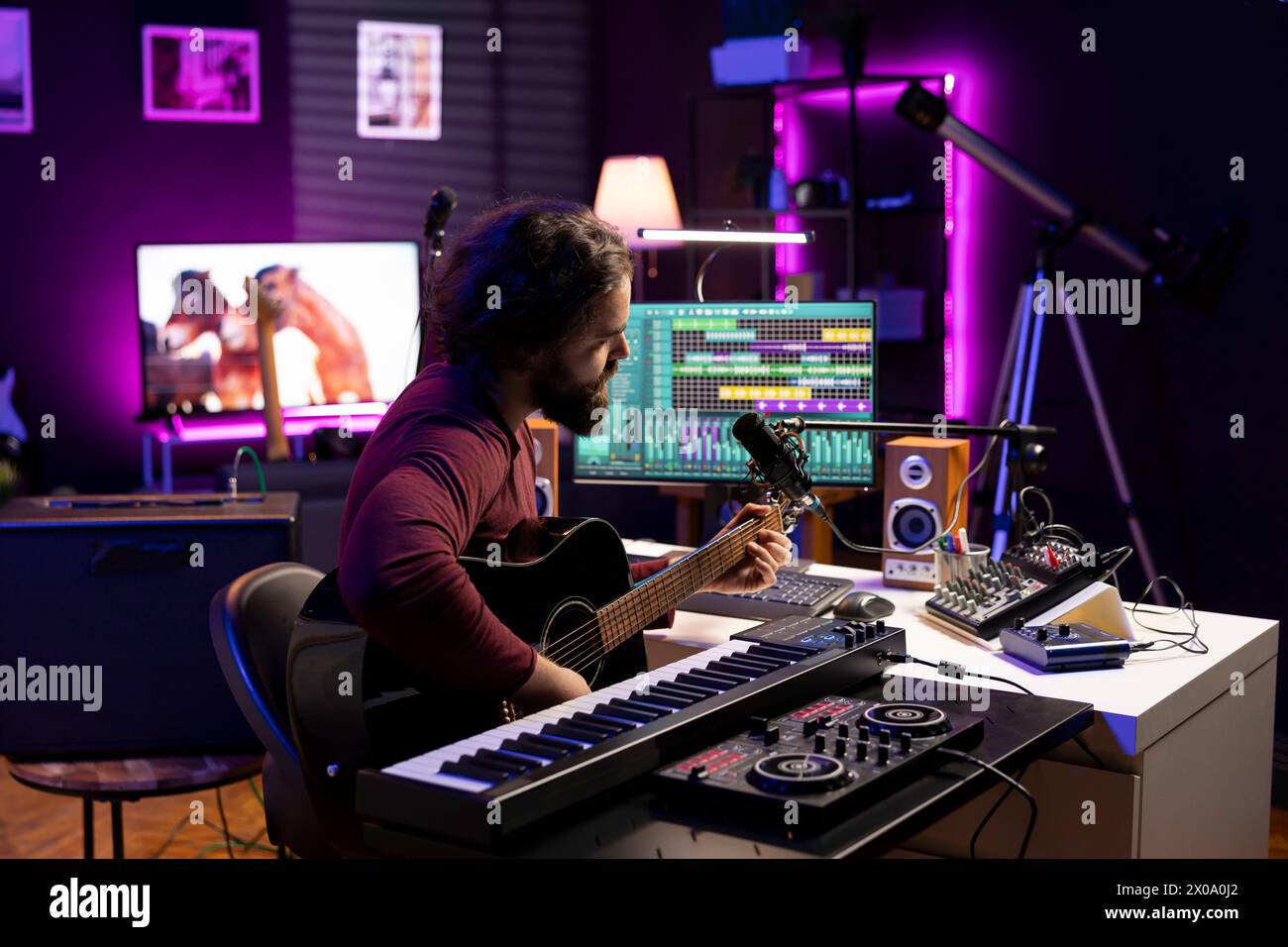 Musical artist recording his acoustic guitar accords in home studio ...