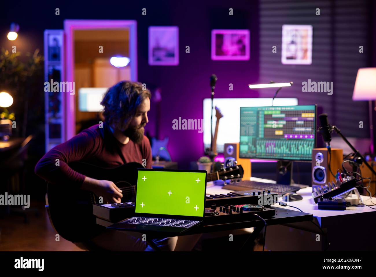 Musical performer playing acoustic guitar next to greenscreen layout on ...