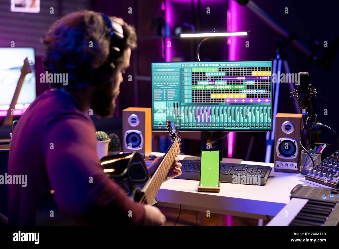 Artist learning to play acoustic instrument in home studio, practicing ...