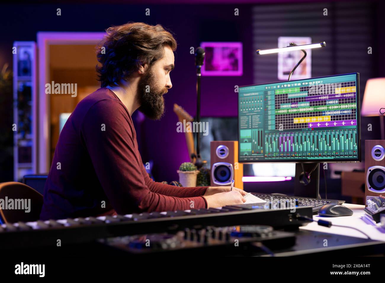 Musical composer writing a song with new lyrics in home studio, recording tunes with audio ...