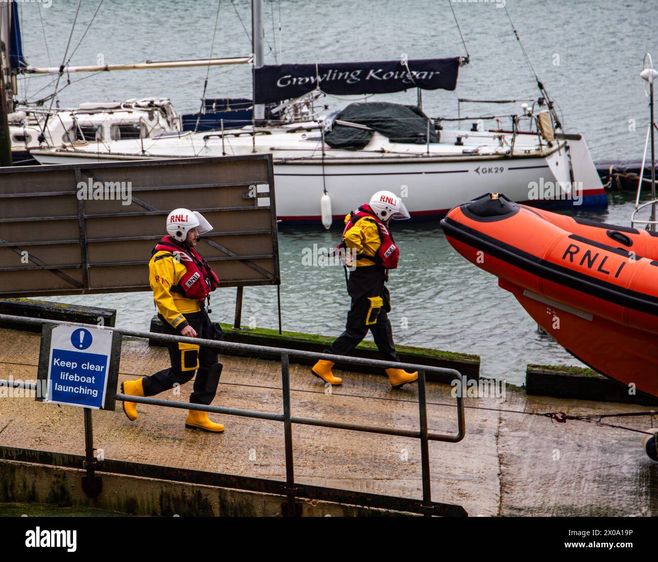 Lifeboat crew walking down the slipway to board the lifeboat Weymouth ...