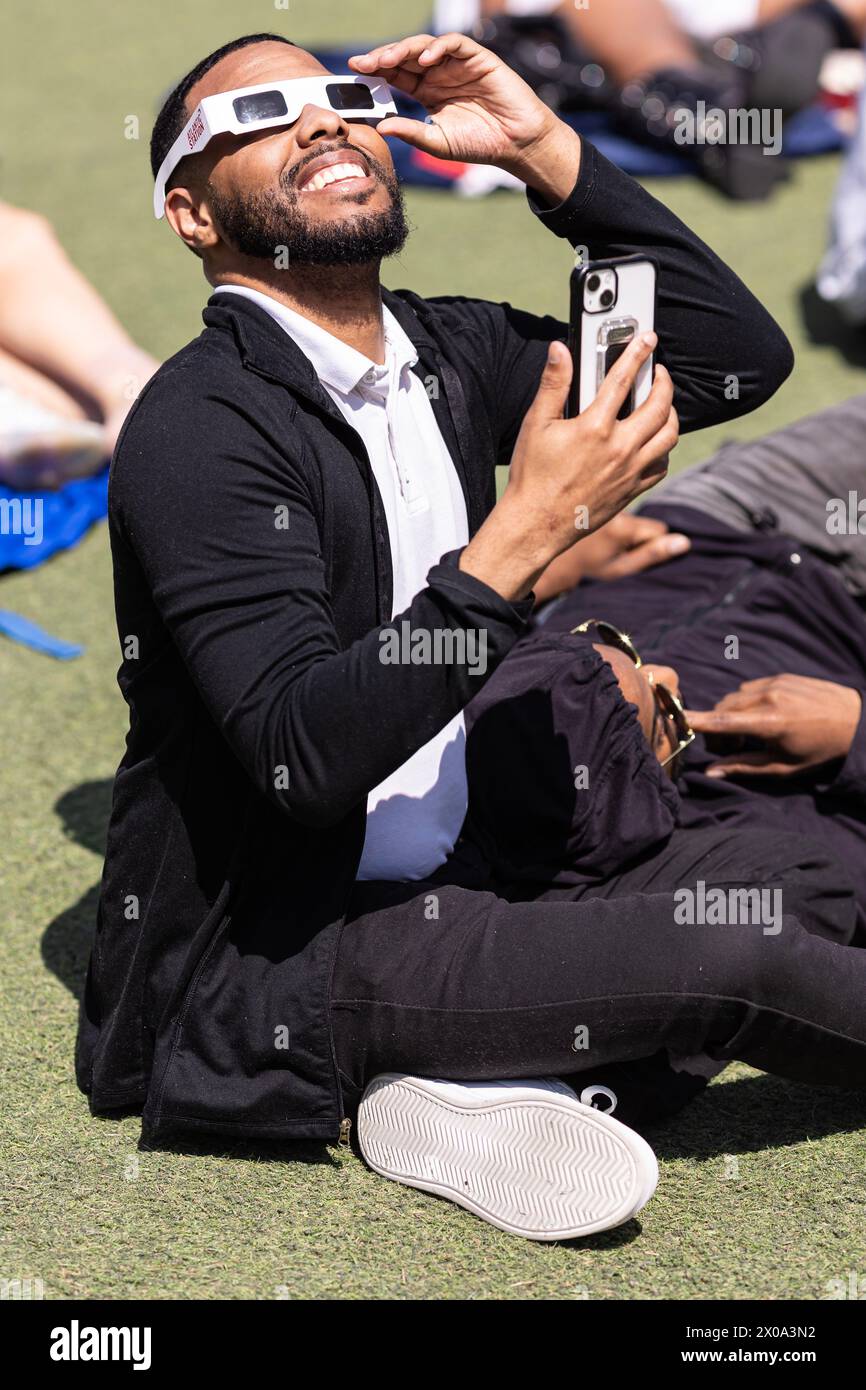 Atlanta, GA / USA - April 8, 2024: A man wears special glasses to view ...