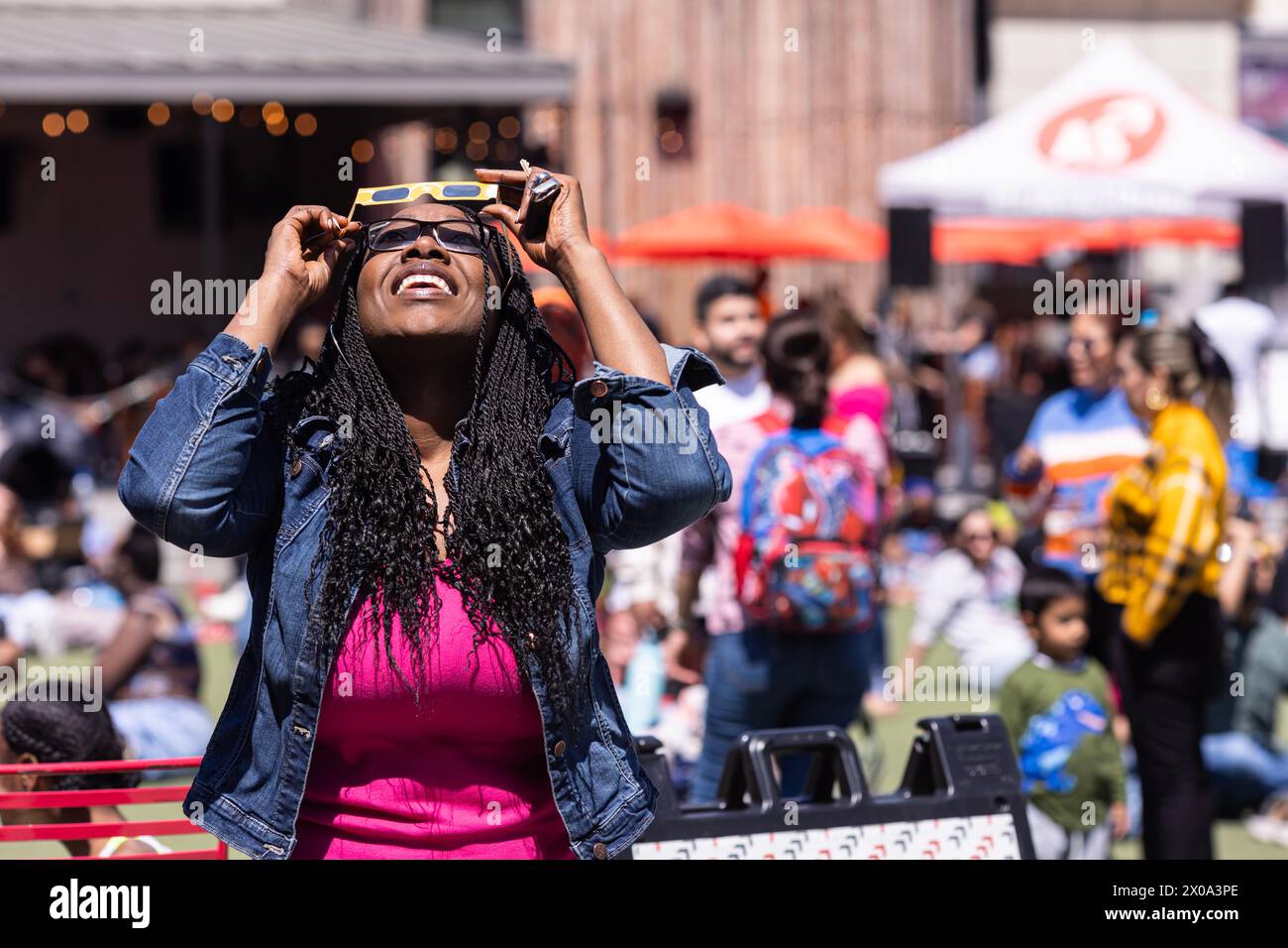 Atlanta, GA / USA - April 8, 2024: A woman uses special glasses to view ...
