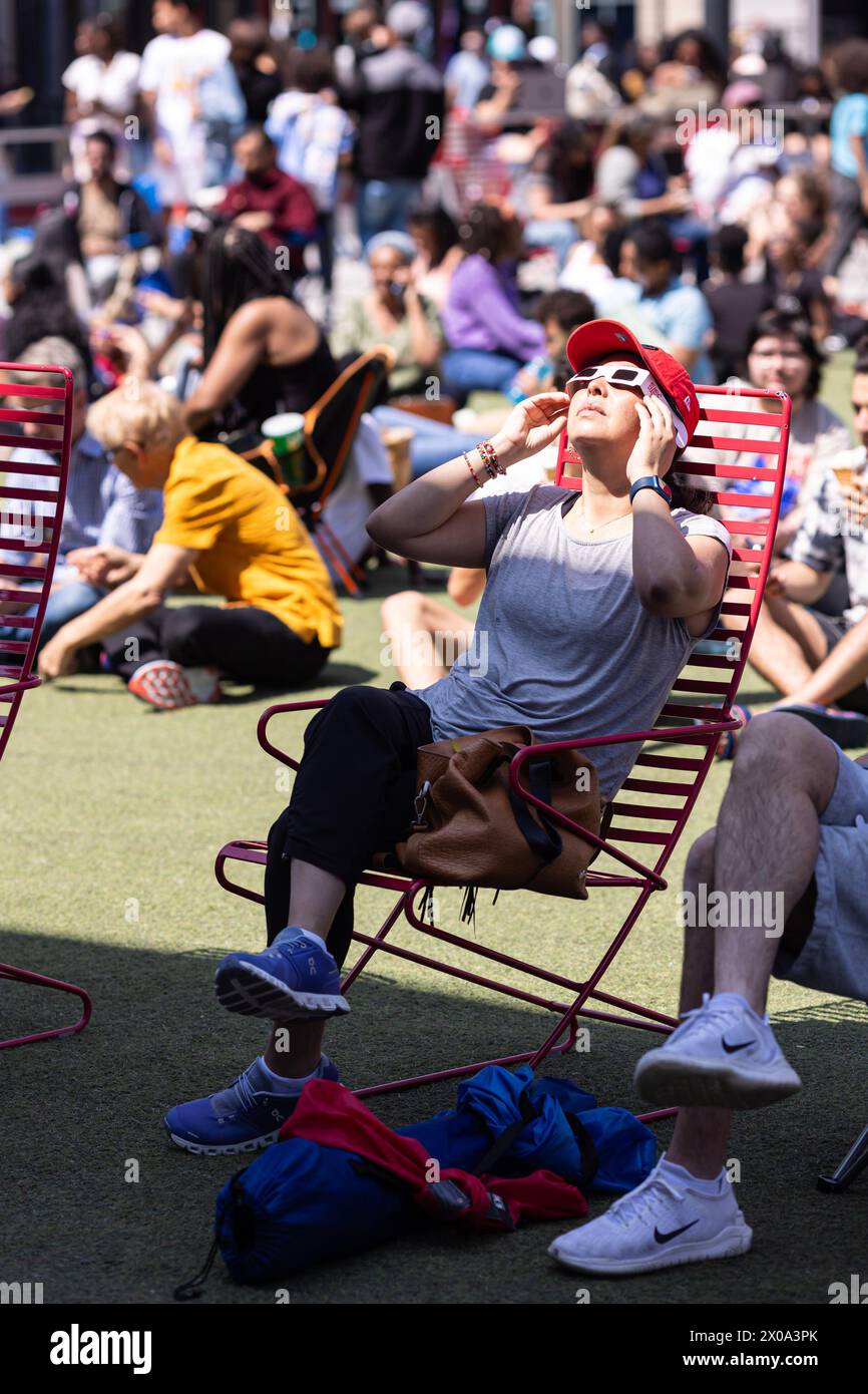 Atlanta, GA / USA - April 8, 2024: A woman wears special glasses to ...