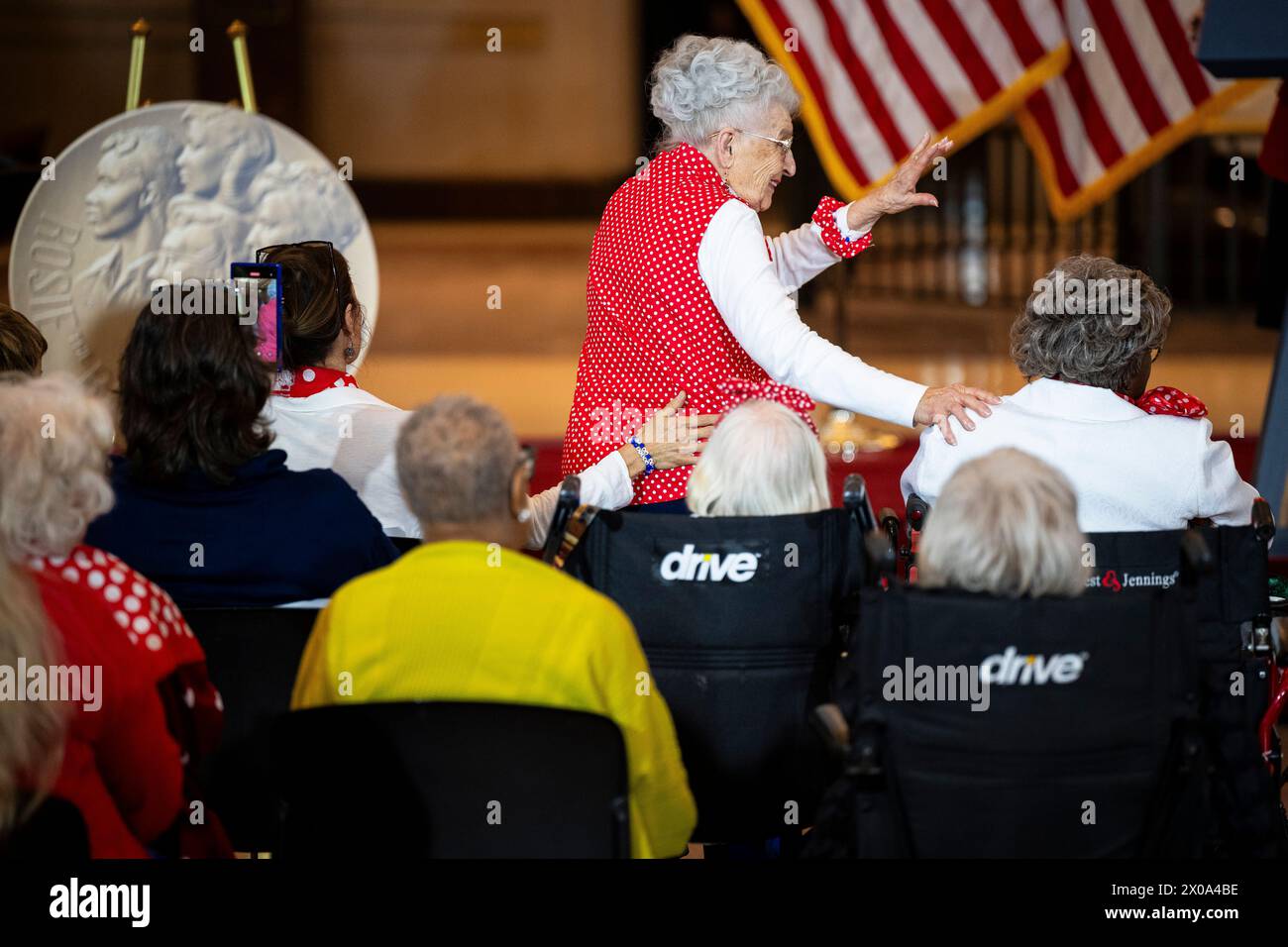 Mae Krier, an award recipient and a “Rosie”, stands and waves during a ...