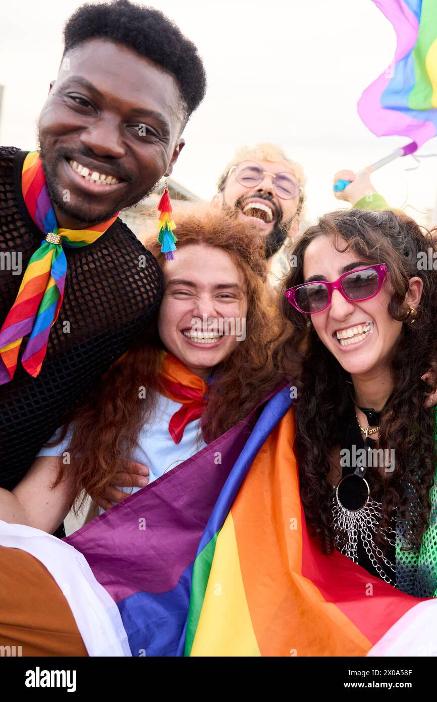 Happy group posing with rainbow flag for a fun event Stock Photo - Alamy