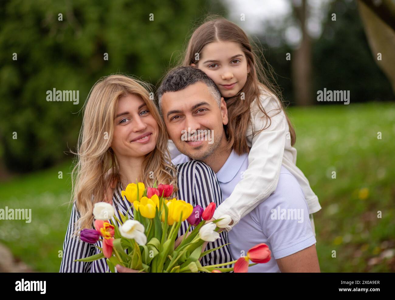 Happy family hugging in park, smiling and enjoying time together Stock ...