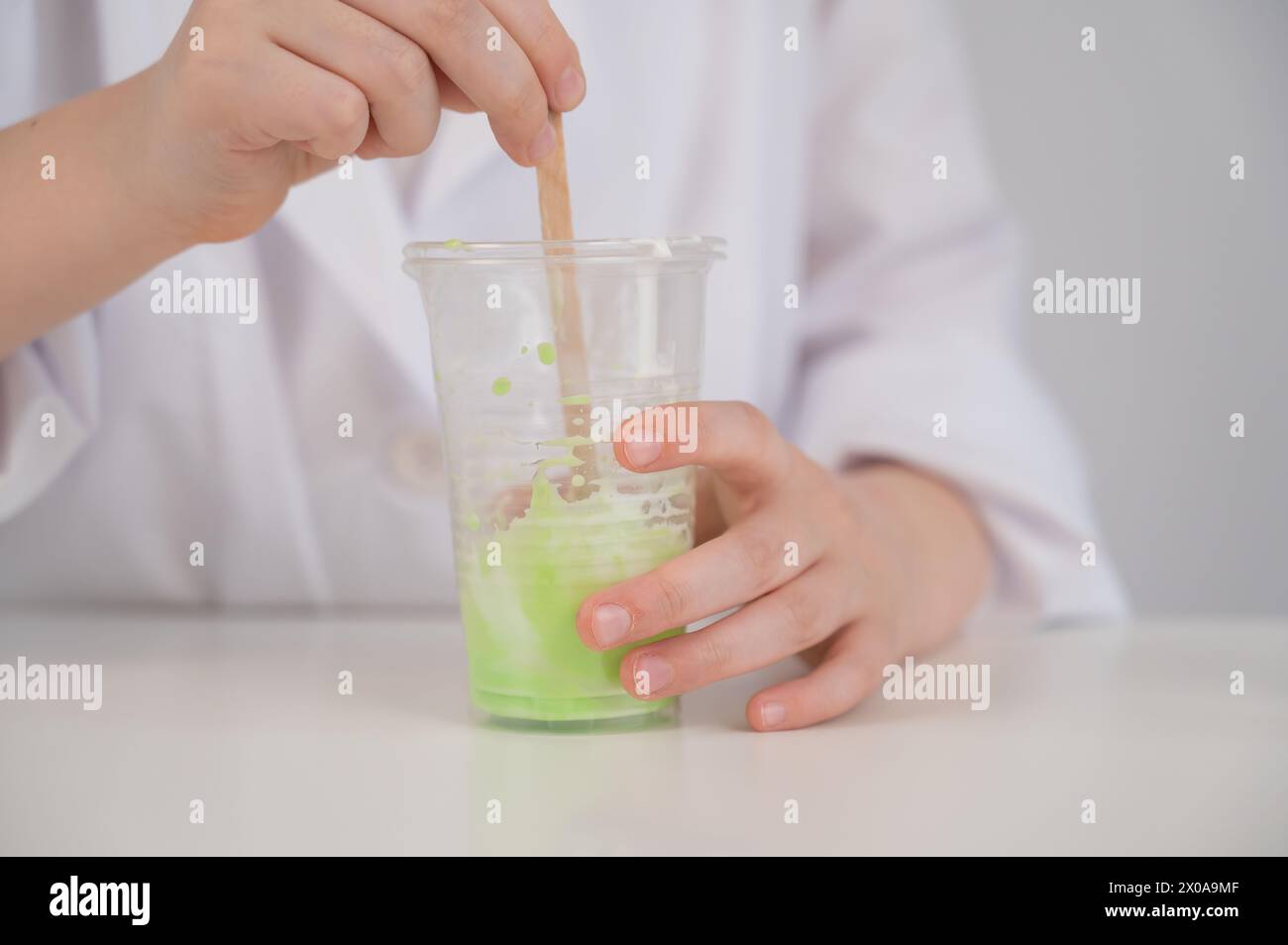 Faceless girl doing chemical experiments on a white background. Making ...