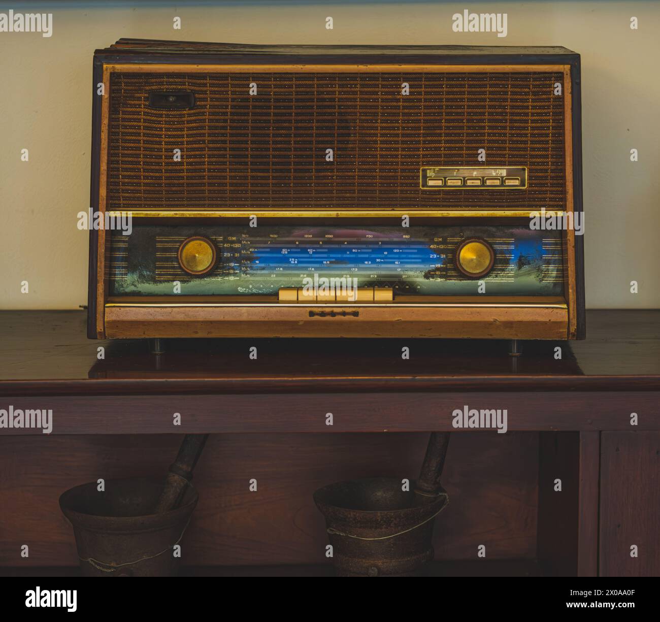 A classic, art deco style radio sits on a rustic wooden shelf. The ...