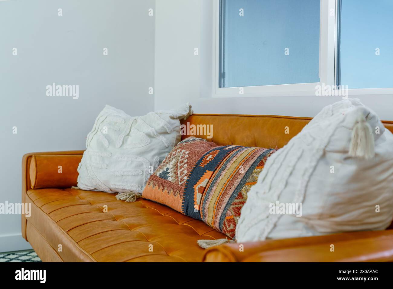 Brown leather couch and decorative southwestern pillows in a modern ...