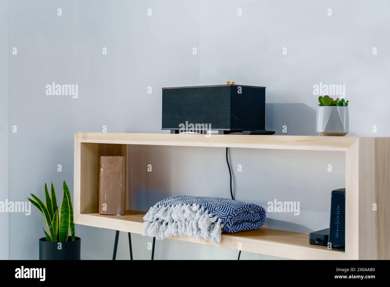 Wood shelf table with hairpin legs radio and folded blanket in a modern ...