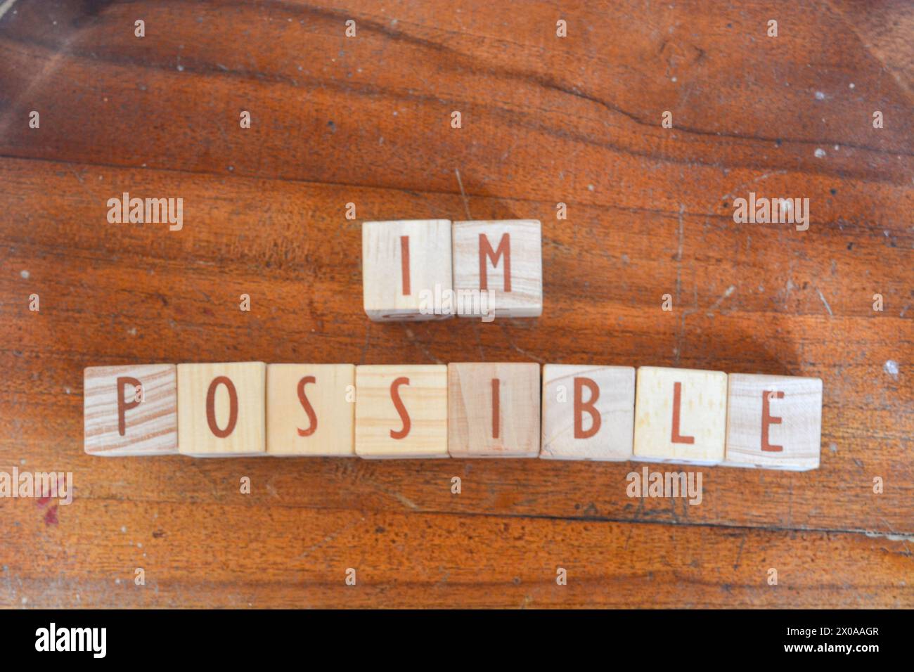 Wooden alphabet blocks isolated on white with sentence "IM POSSIBLE ...