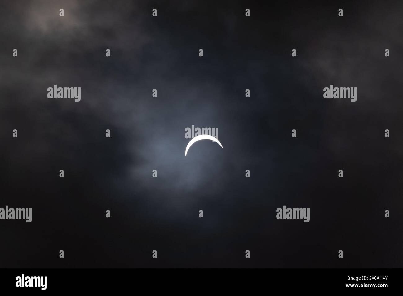 Partial solar eclipse - moon covers sun, dark clouds, celestial drama ...