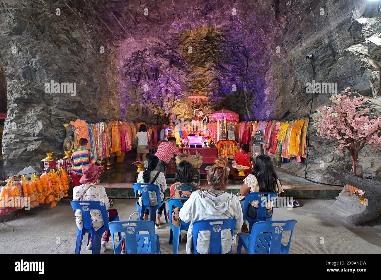 People praying & making offerings of marigold garlands & traditional ...