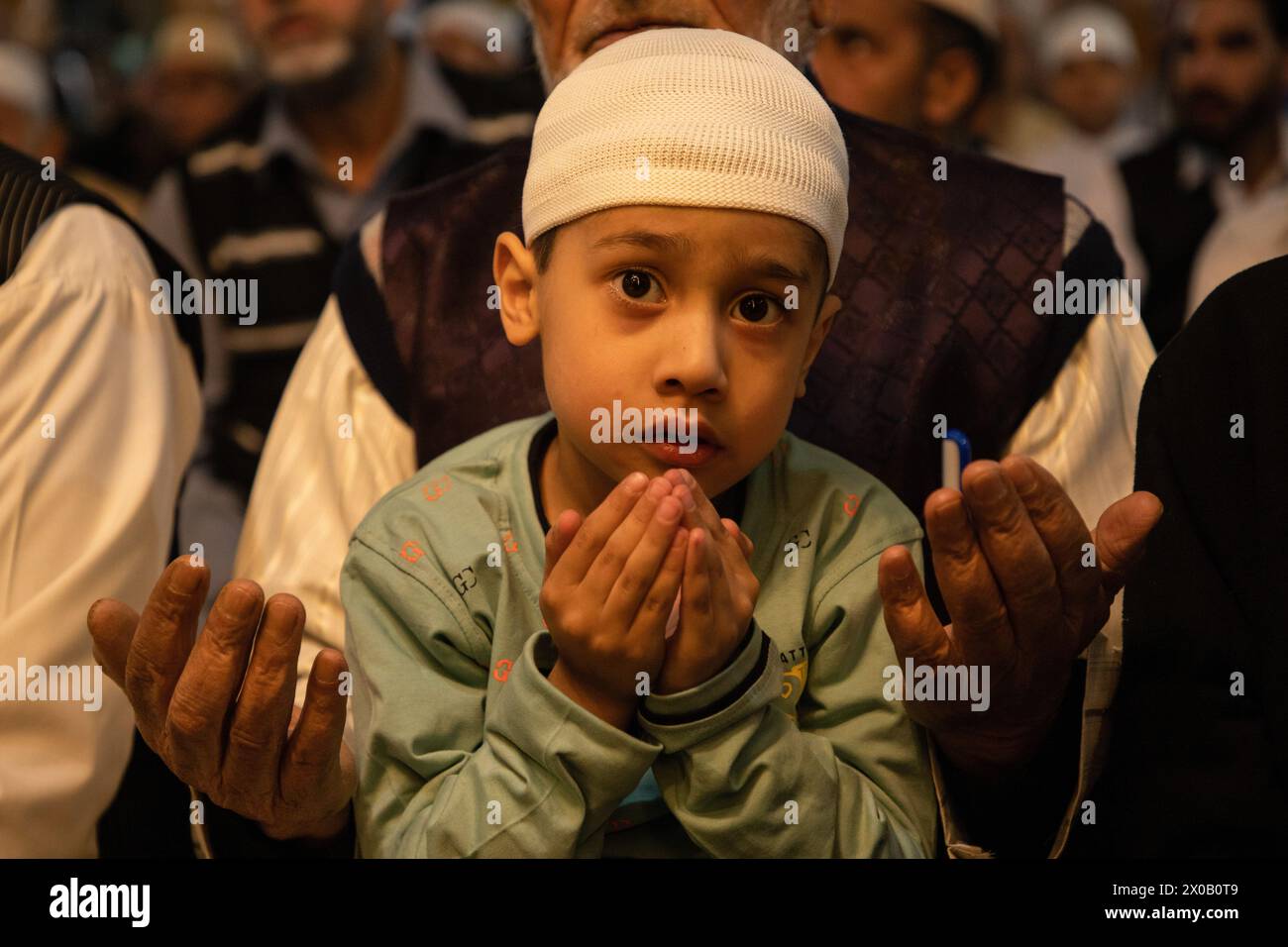 A Kashmiri boy offers Eid-Al-Fitr prayers at a mosque in Srinagar. Eid ...