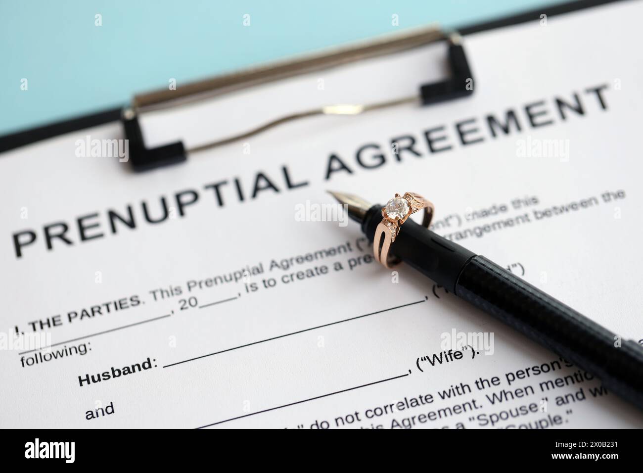Prenuptial agreement and wedding ring on table. Premarital paperwork ...
