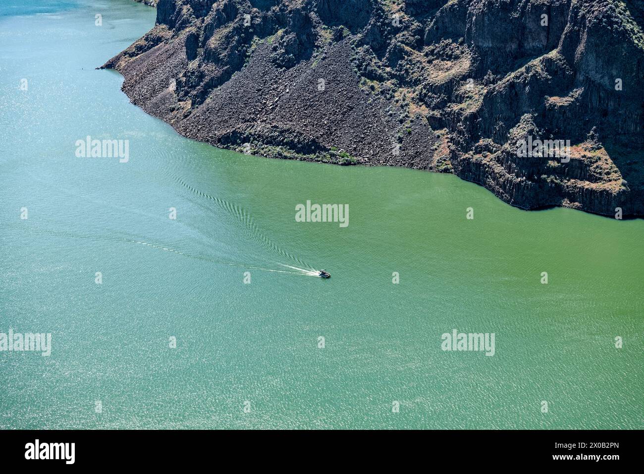 A pontoon boat runs below the towering cliffs on the Crooked River at ...