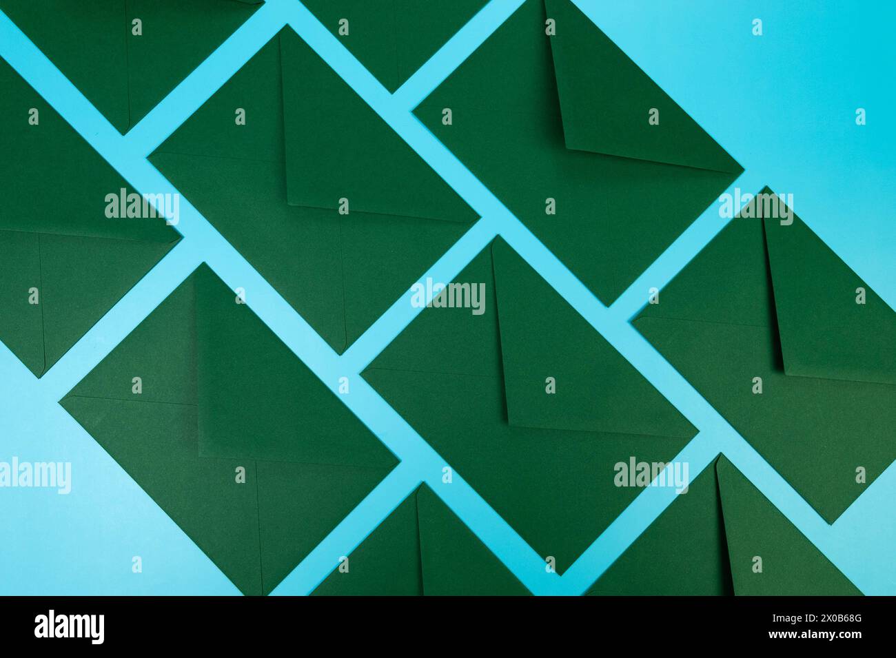 Top view of dark green envelopes on blue background. Post flat lay ...