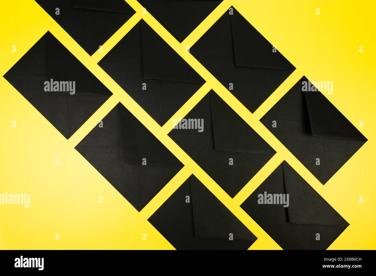 Top view of black envelopes on yellow background. Post flat lay. Copy ...