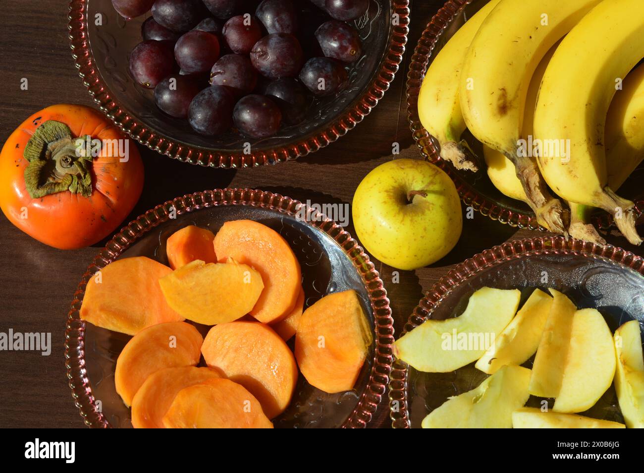 Variety of everyday fruits like banana apple grapes and persimmon good ...