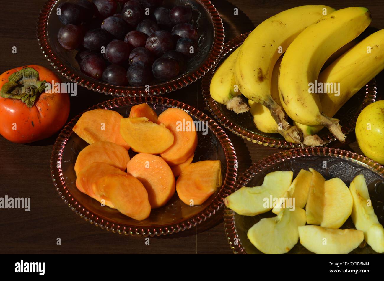 Variety of everyday fruits like banana apple grapes and persimmon good ...