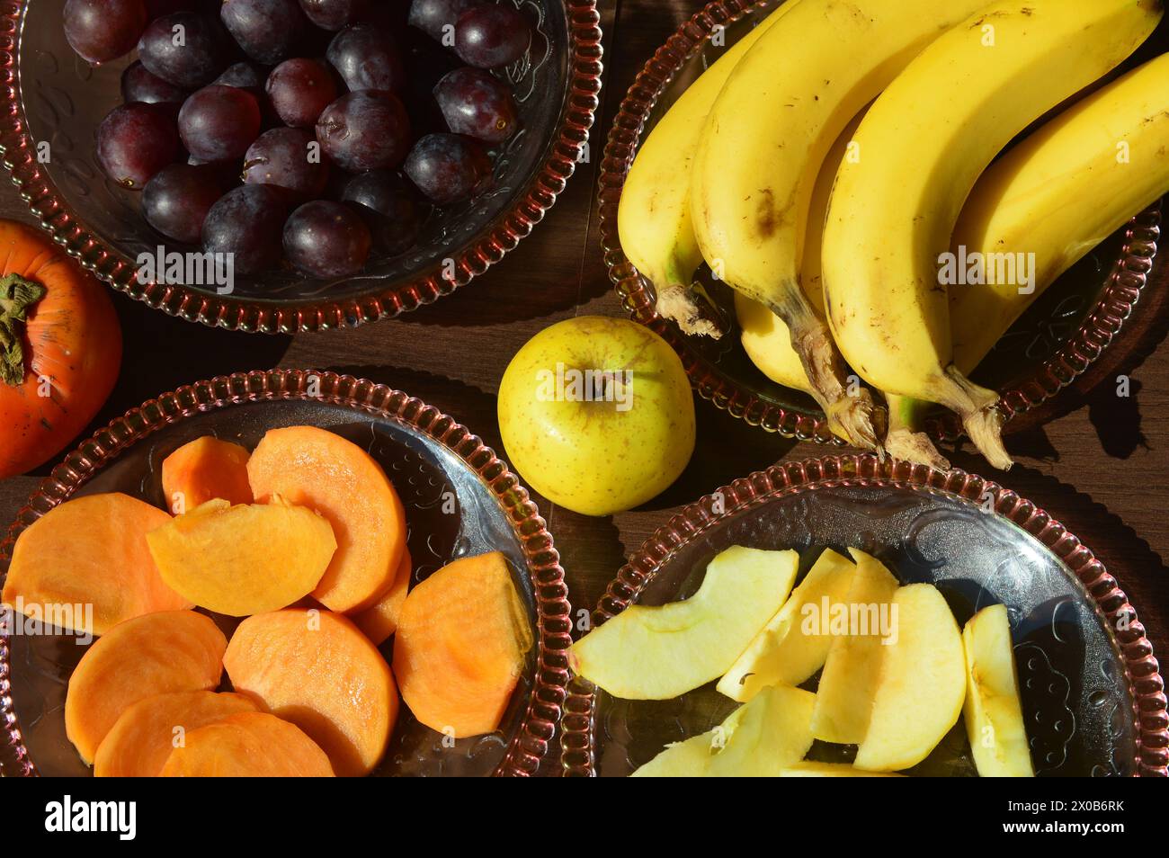 Variety of everyday fruits like banana apple grapes and persimmon good ...