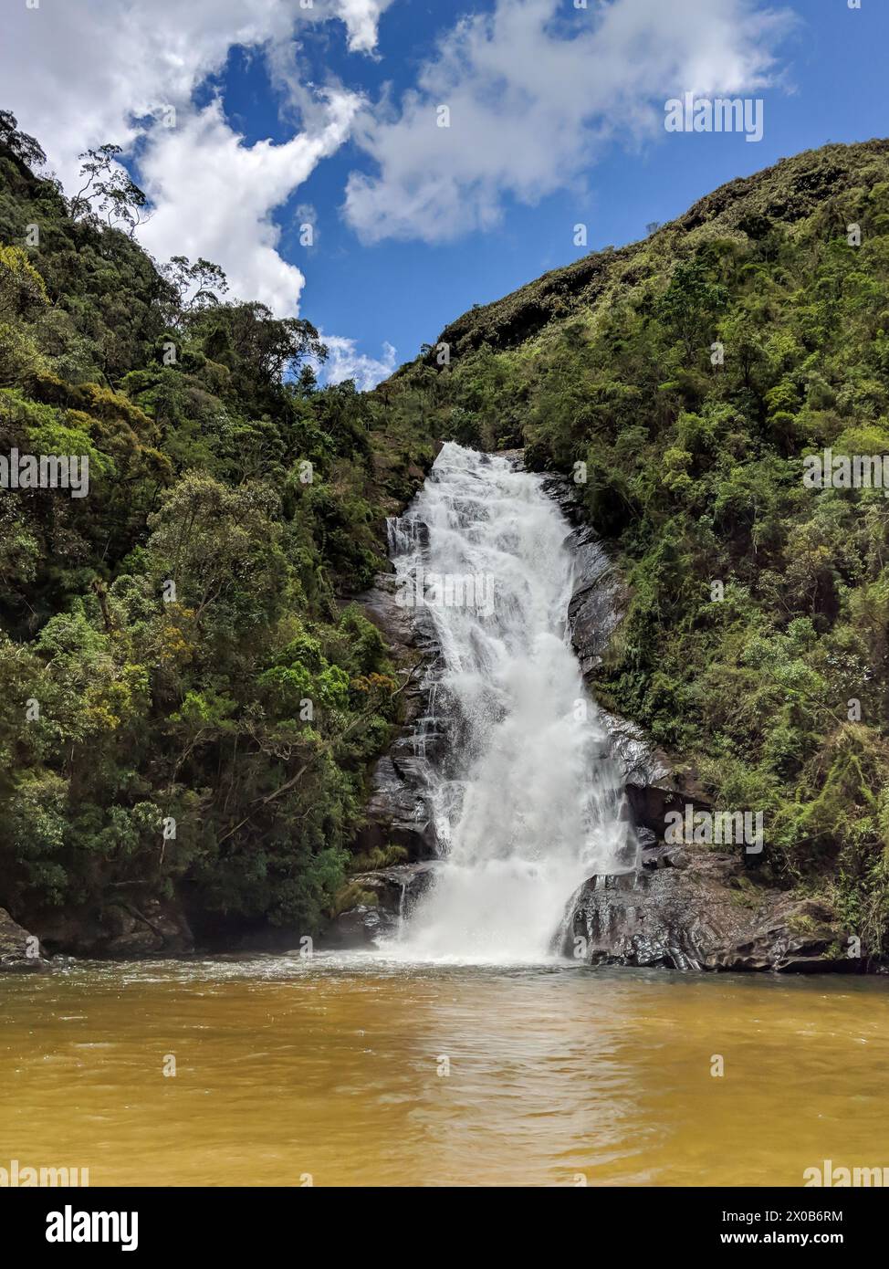 A beautiful waterfall between mountains flowing into a beautiful orange ...