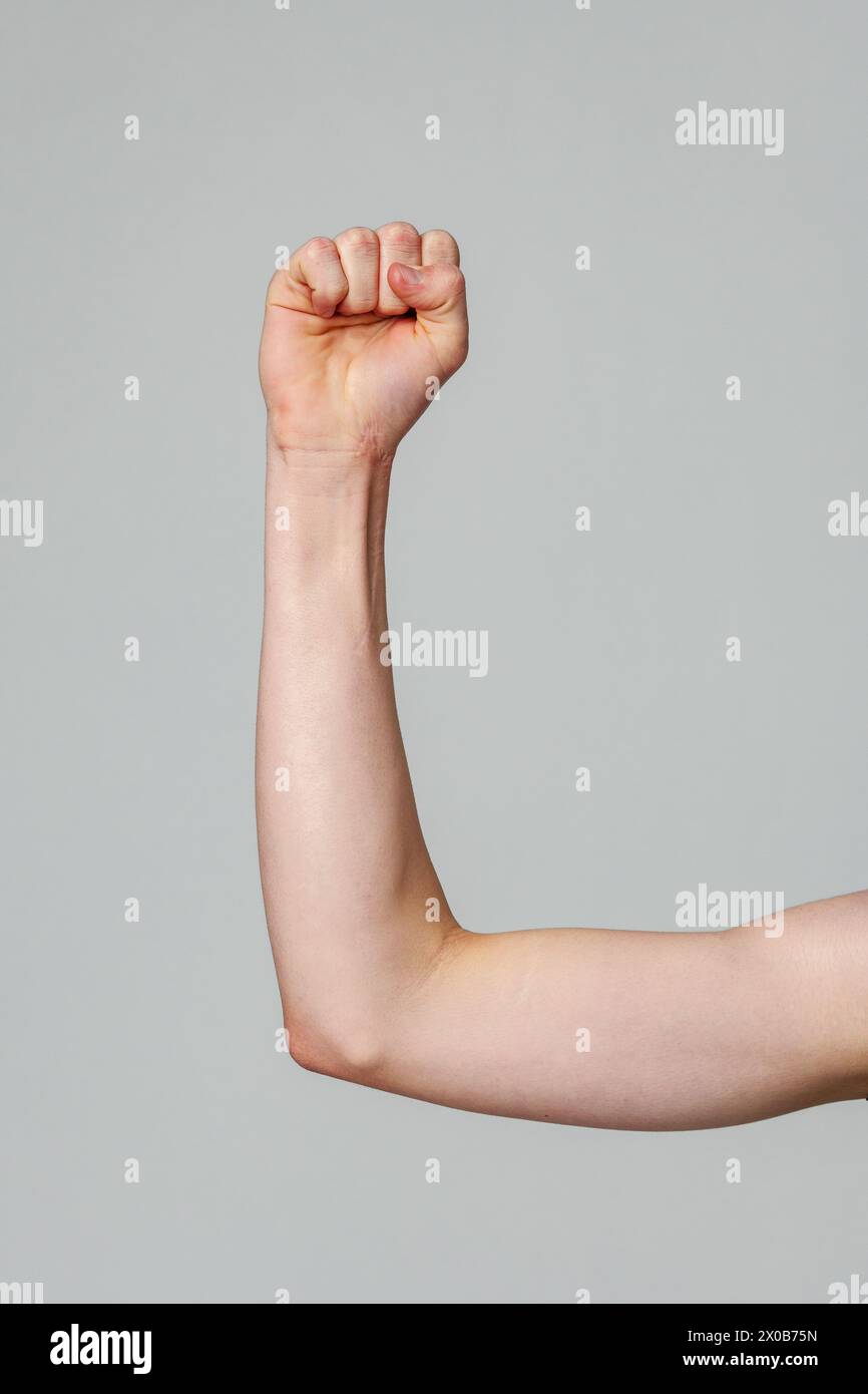 Raised Right Arm With a Clenched Fist Against a Neutral Background ...