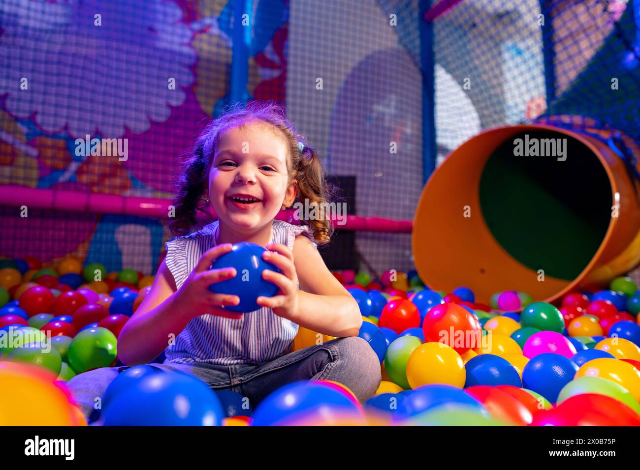 Joyful Young Girl Playing in a Colorful Ball Pit at an Indoor ...