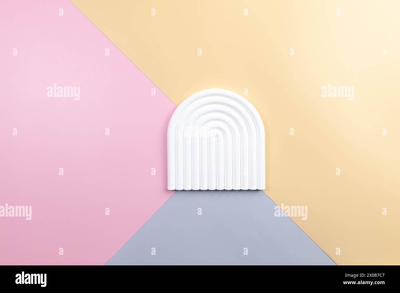 Top view of white arch on colourful background. Blue, pink and yellow ...