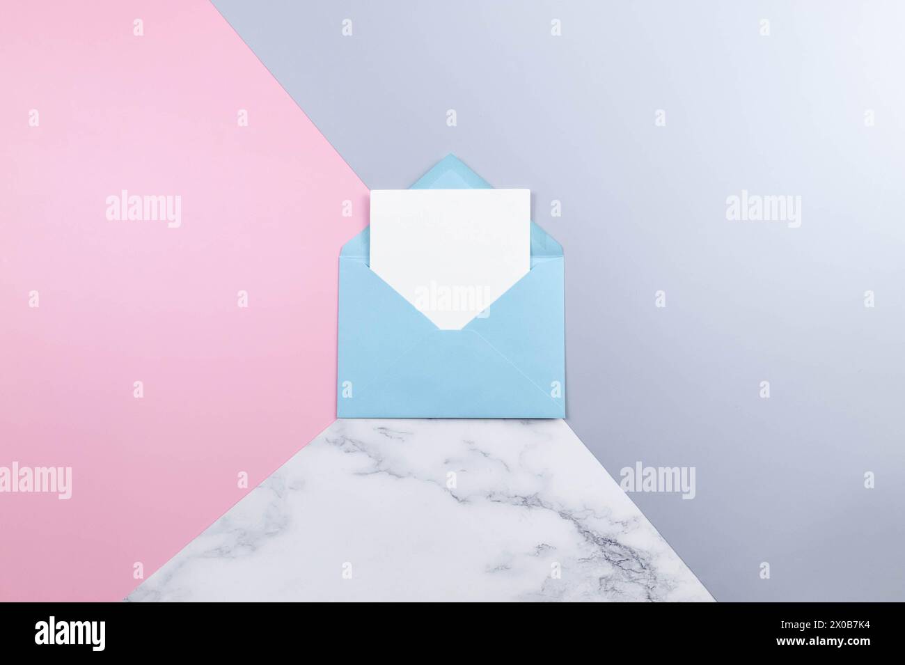 Top view of light blue envelope, white card on colourful background ...