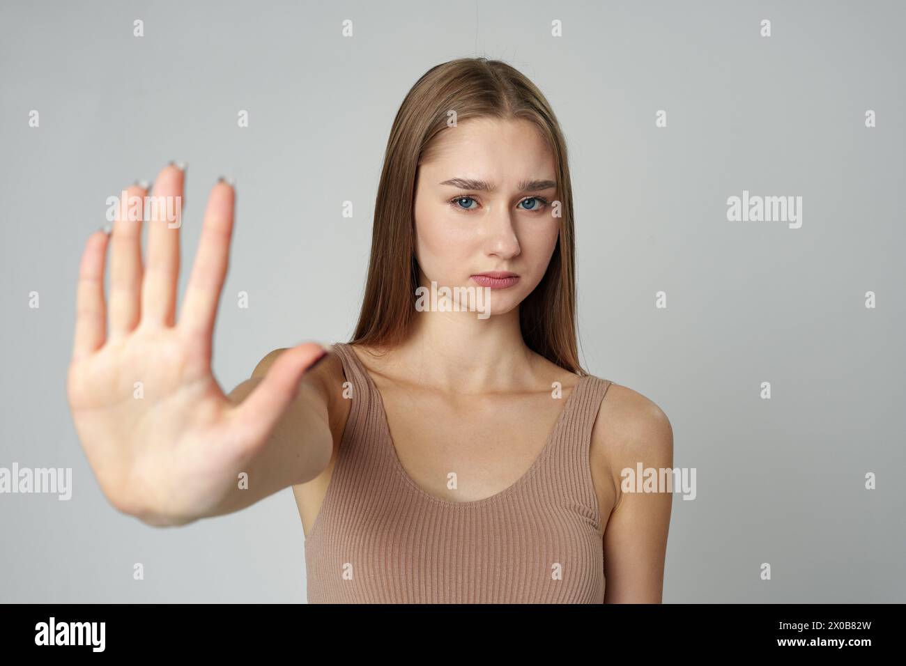 Young Woman in Fashionable Outfit Standing Against a Neutral Backdrop ...