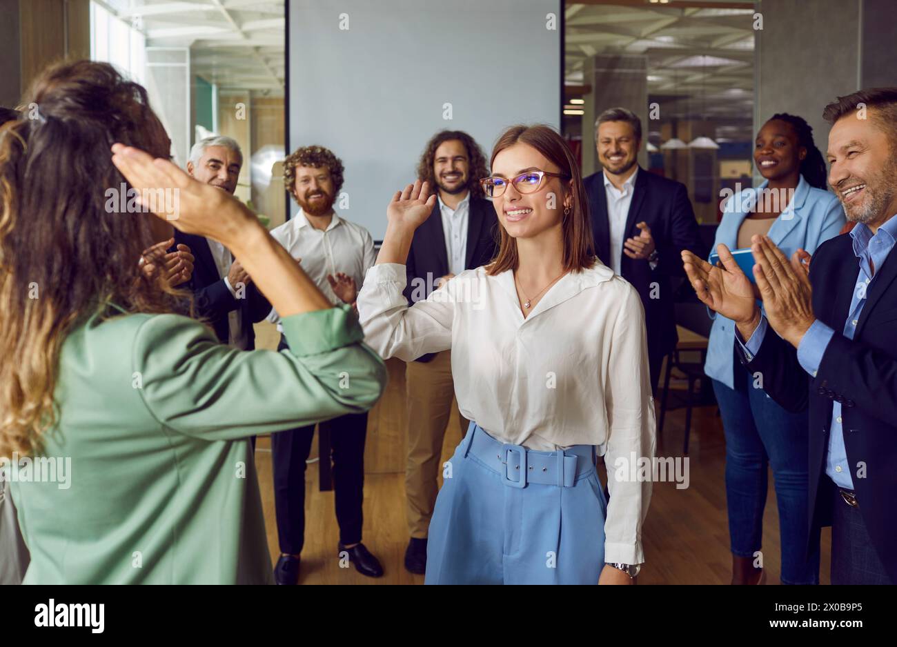 Happy colleagues giving high five at meeting at office, celebrating ...
