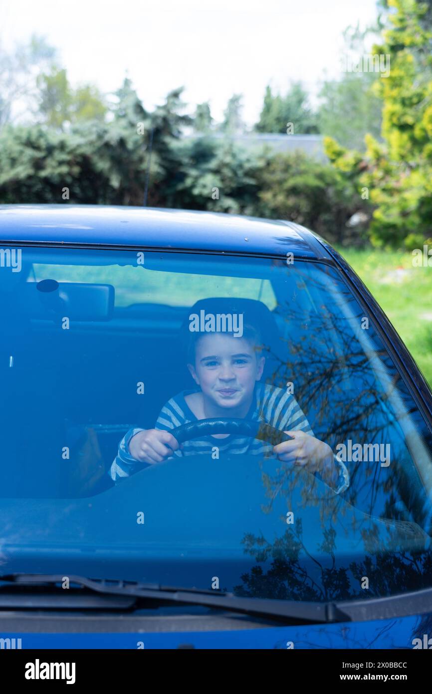 Naughty child playing pranks while driving an adult car Stock Photo - Alamy