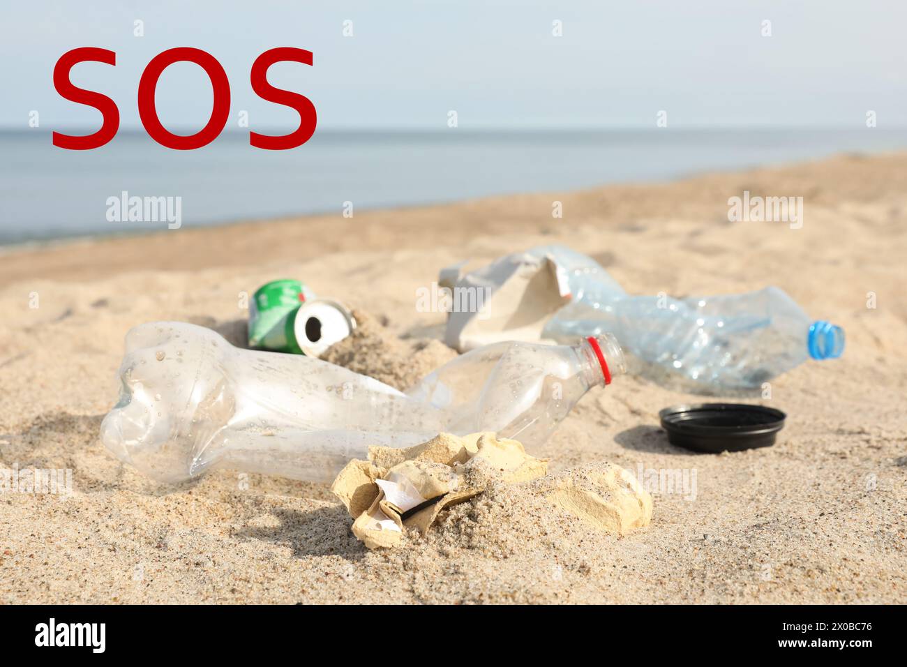 Word SOS and garbage scattered on beach near sea. Recycling problem ...