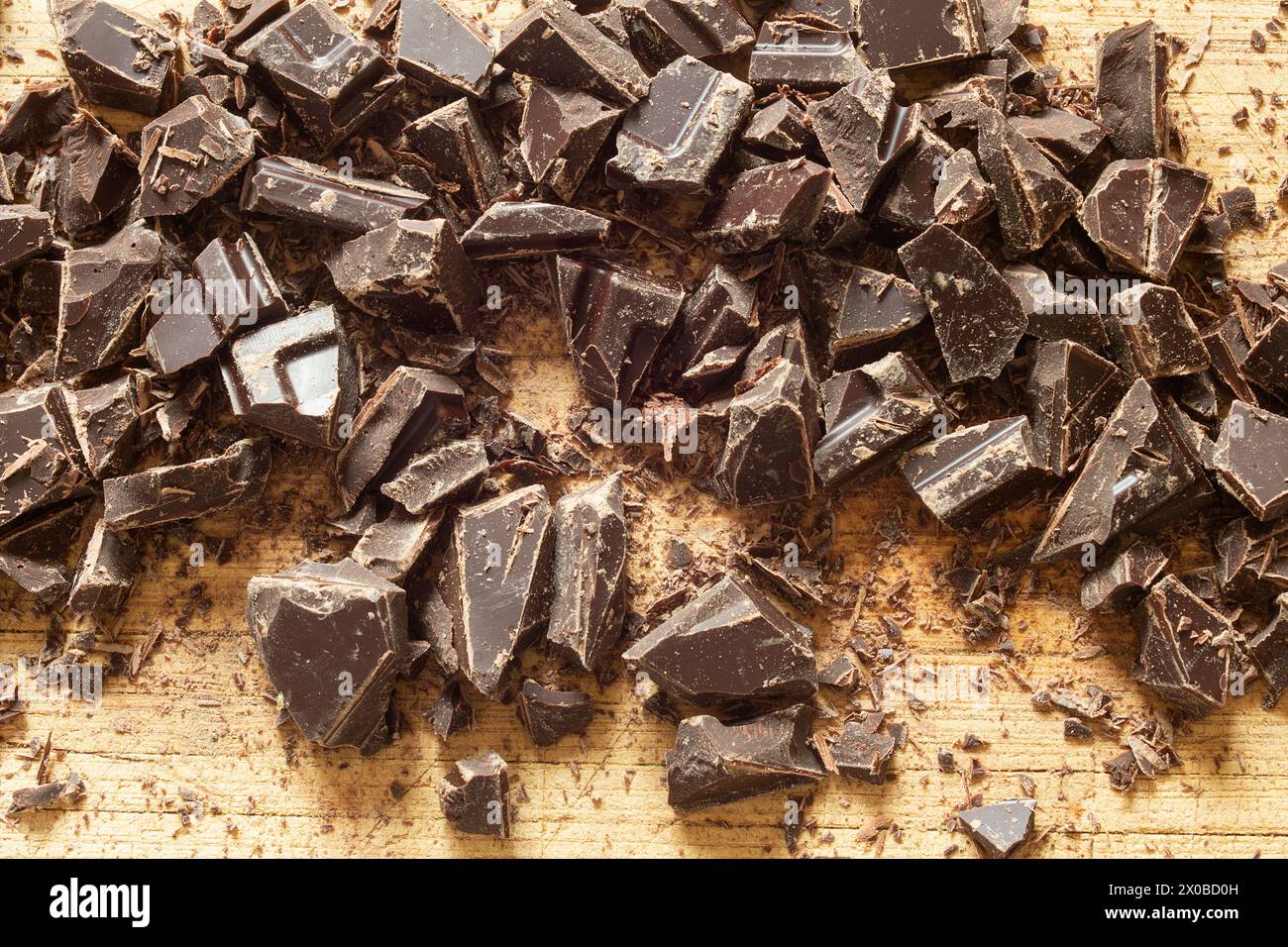 A lavish spread of dark chocolate chunks on a rustic wooden cutting ...