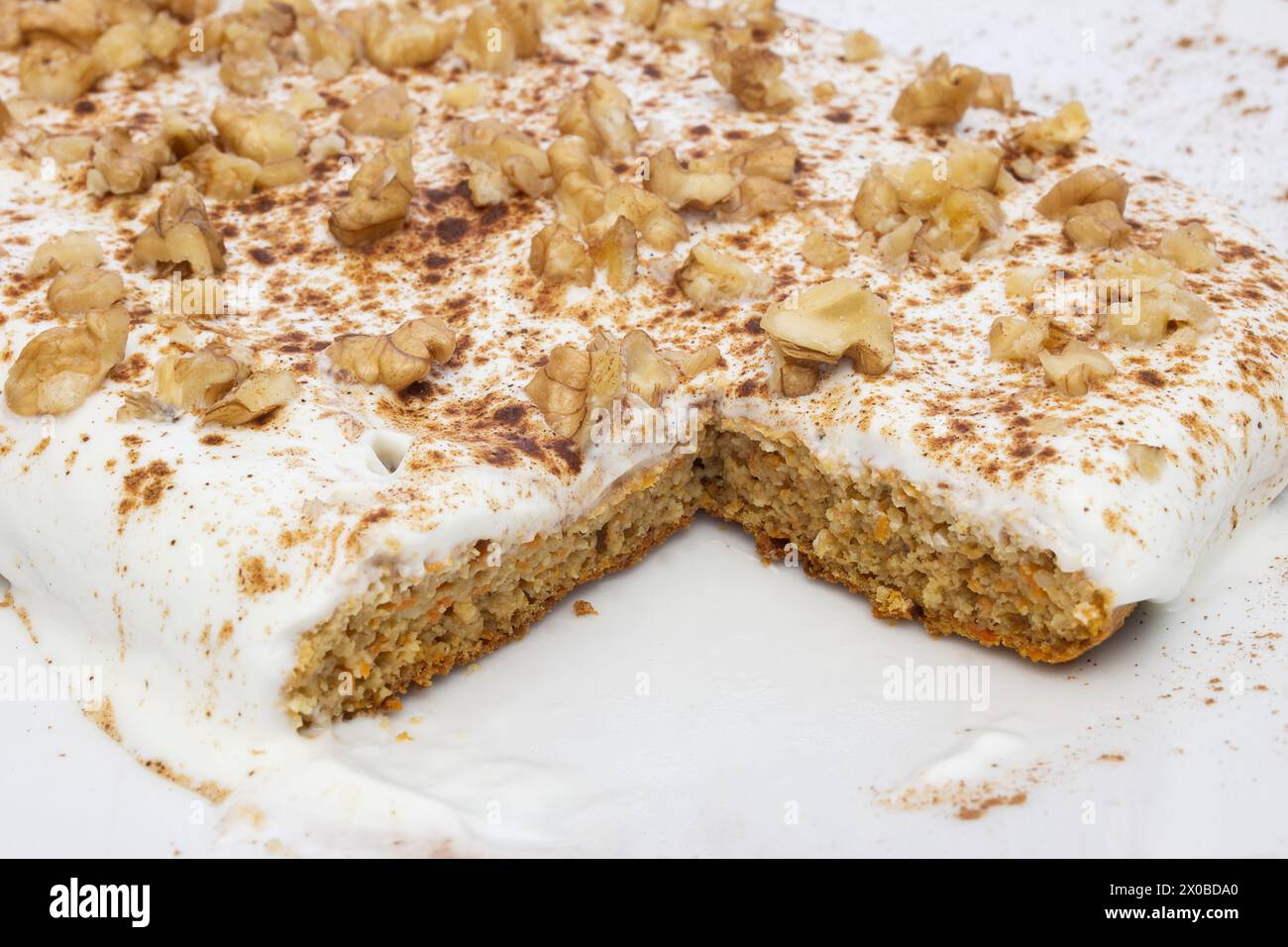 Close-up of a homemade carrot cake with a bite taken out, revealing the ...