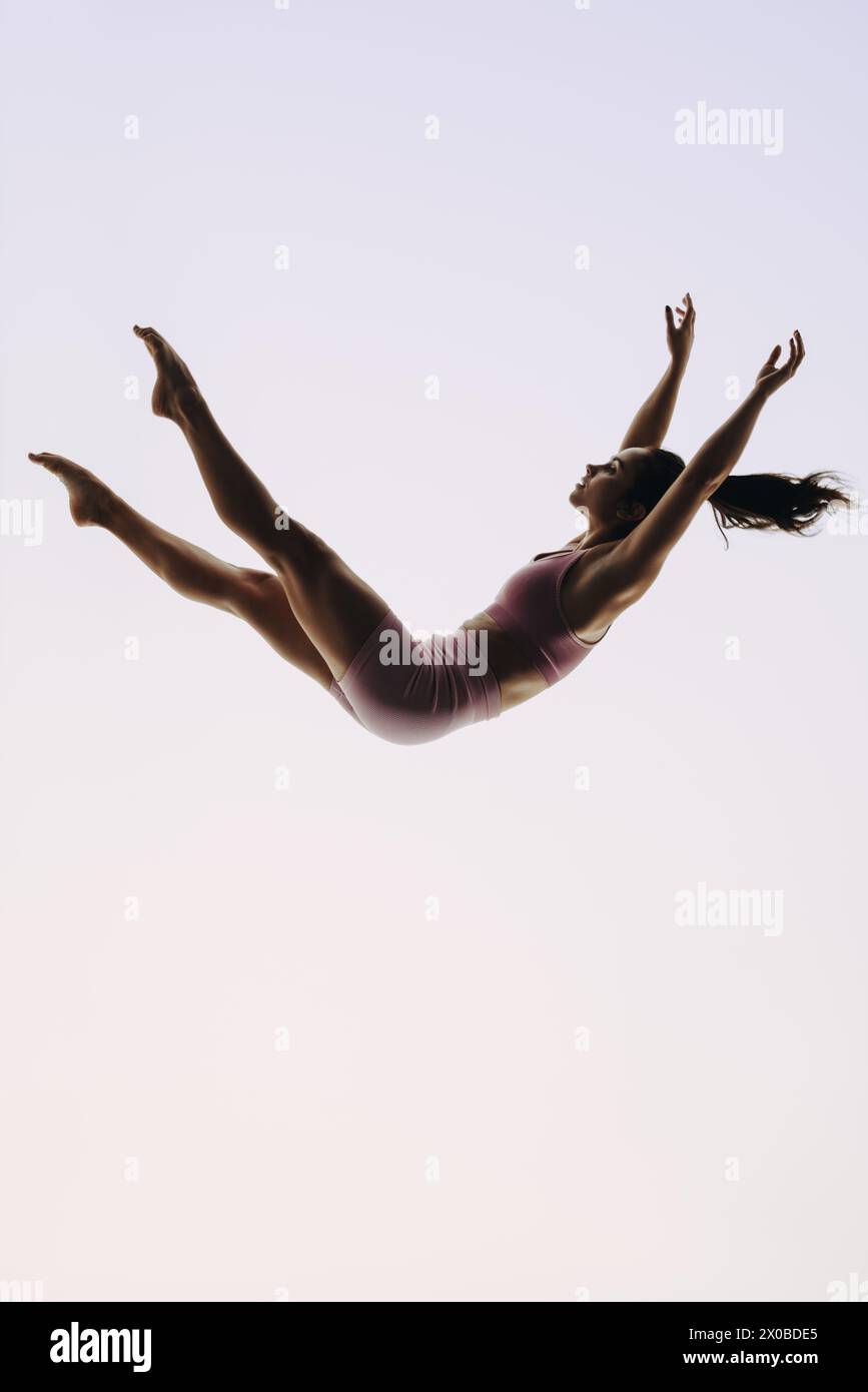 Professional gymnast, dressed in fitness clothing, displays her agility ...