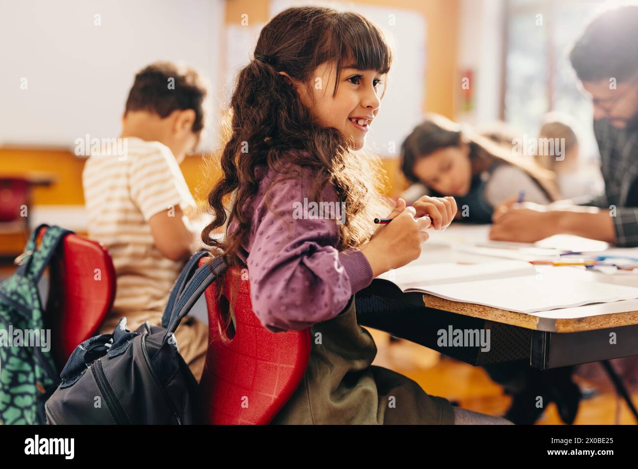 Education and child development. Little girl smiles while sitting in a ...