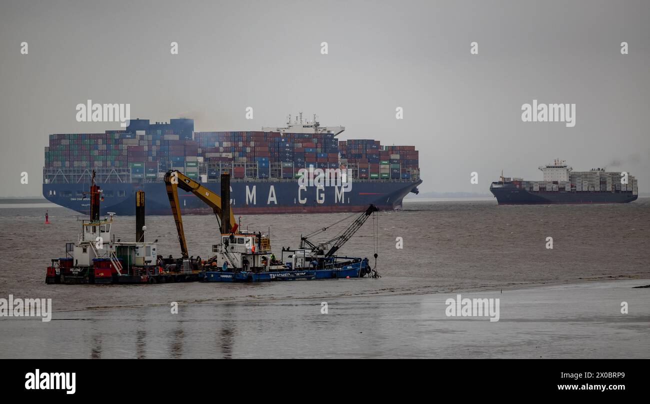 11 April 2024, Schleswig-Holstein, Brunsbüttel: Container ships pass ...