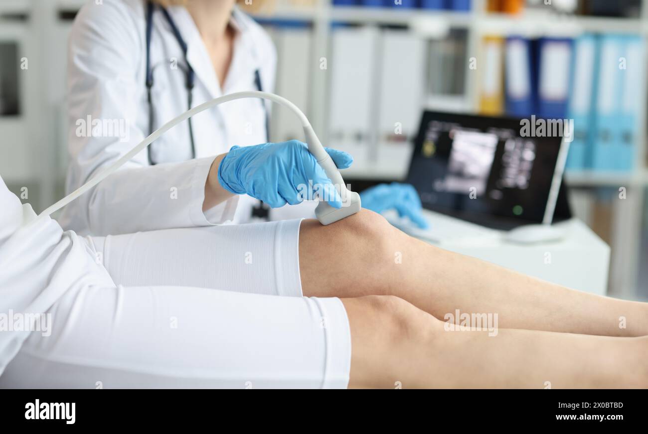 Orthopedic doctor makes ultrasound examination of tpatient knee in ...