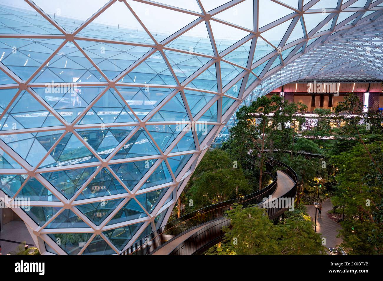 Massive glass dome and elevated walkway above indoor garden at the ...