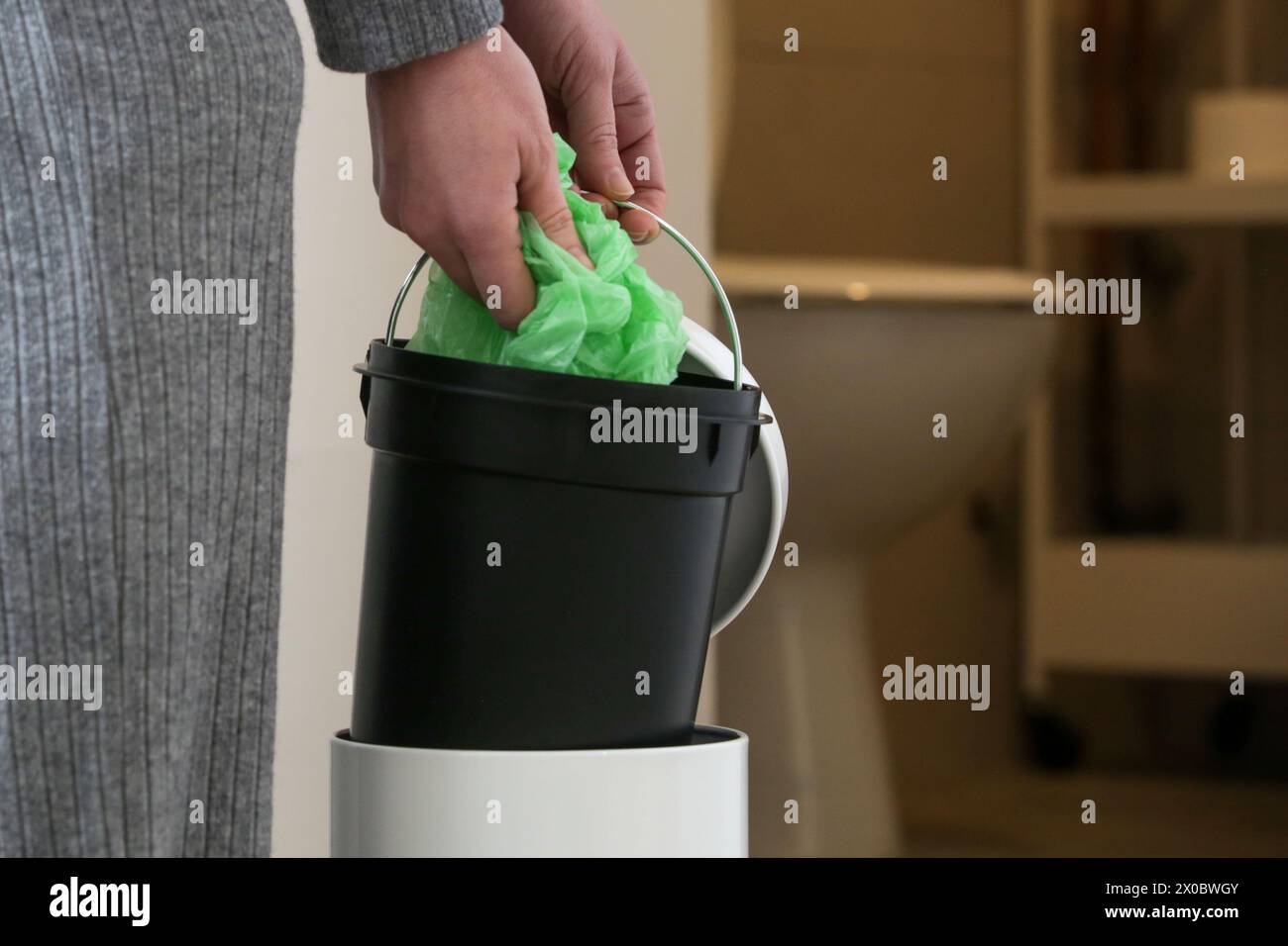 Housewife throwing away garbage, taking of plastic garbage bag from the ...