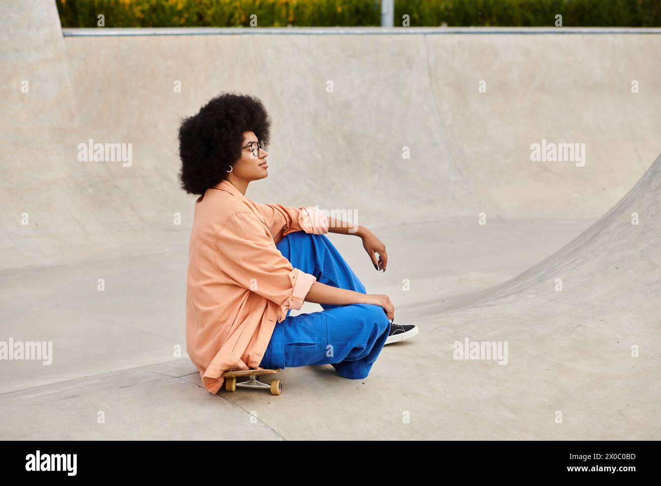 A young African American woman with curly hair confidently sits on a ...