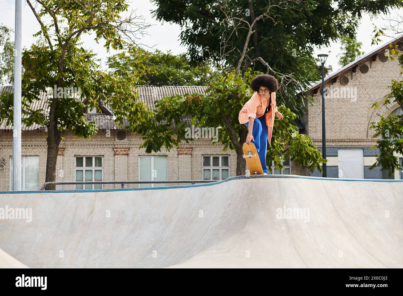 A man skillfully rides his skateboard up the side of a ramp, defying ...