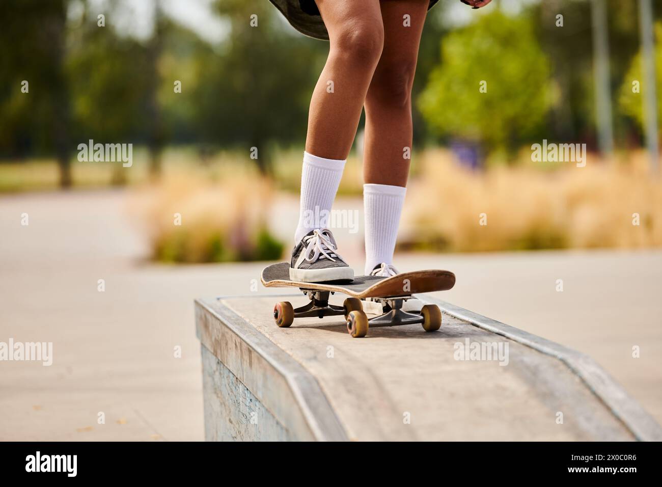 A young African American woman performs a daring skateboard trick on a ...