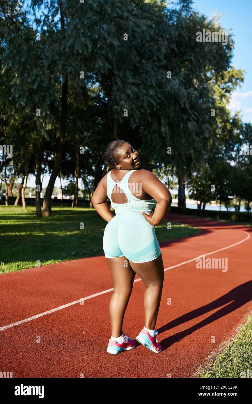 An African American woman in sportswear stands confidently on a tennis ...